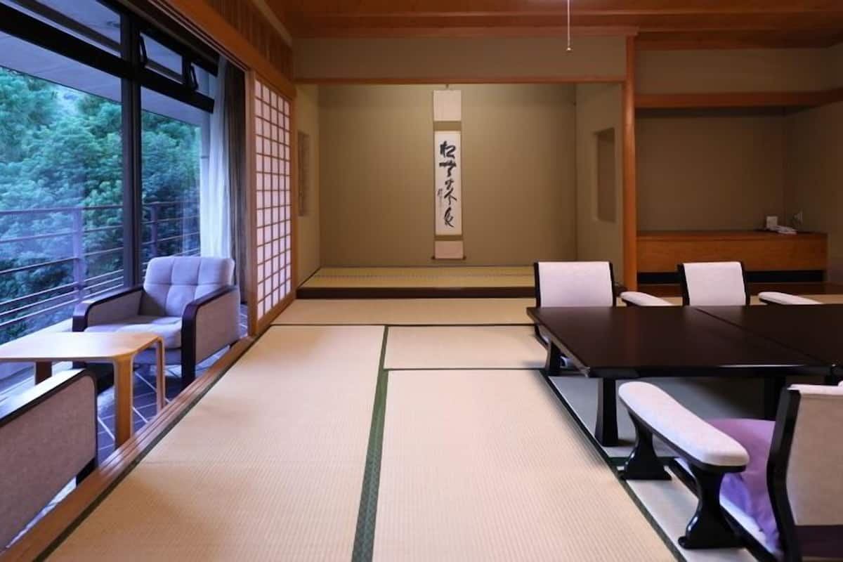 Um quarto japonês tradicional com tatames, uma mesa baixa e cadeiras.