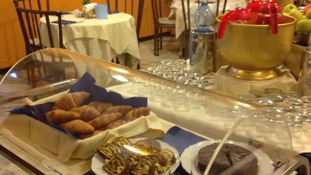 Disposição de buffet com diversos alimentos e uma vitrine de vidro.