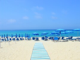 Uma praia privada, espreguiçadeiras, guarda-sóis de praia 