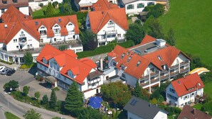 Zona residencial com várias casas de telhado vermelho, algumas com varandas, e um hotel visível também com telhado vermelho.