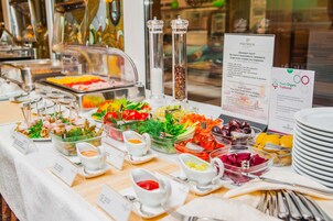 Uma mesa de buffet com diversos alimentos e acompanhamentos.