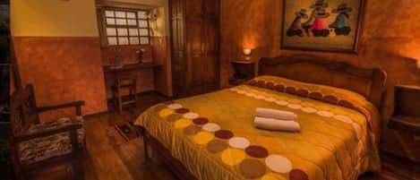 Quarto com cama grande, móveis de madeira, escrivaninha e um quadro na parede.