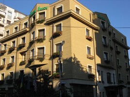 Um hotel de vários andares com sacadas decoradas com jardineiras floridas.