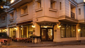 Um hotel de vários andares com estilo arquitetônico clássico, com varandas e um restaurante no térreo.