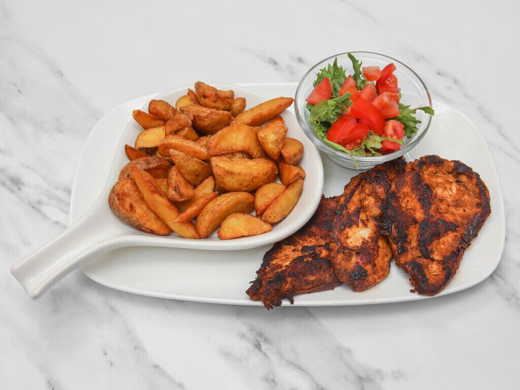 Prato com frango grelhado, batatas fritas e uma salada.