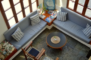 Uma sala de estar moderna com um sofá seccional cinza, uma mesa de centro redonda e uma pequena mesa lateral.
