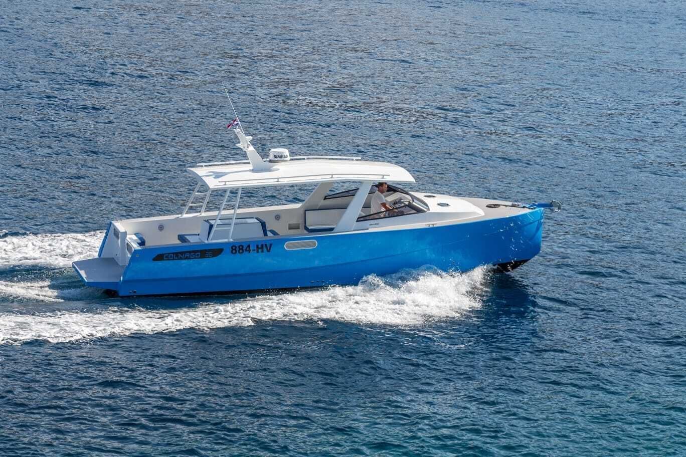 Um barco motor de passeio azul com o número de registo 884-HV na água.