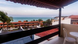 Varanda com vista para o oceano e edifícios de hotel.