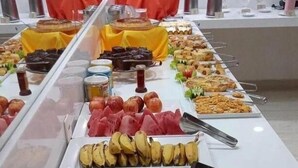 Buffet com diversas frutas e sobremesas.