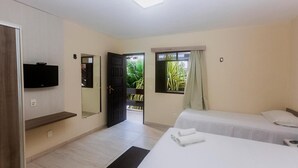 Quarto de hotel com duas camas, televisão, espelho e janela com cortinas.