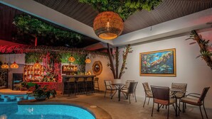 Uma área de bar com piscina, assentos e uma grande moldura na parede.
