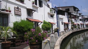 Um edifício à beira de um canal com uma placa que diz 'River One Guest House'.