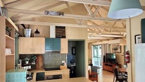 Uma cozinha espaçosa com armários de madeira, painel de azulejos e um espaço de jantar com mesa e cadeiras.