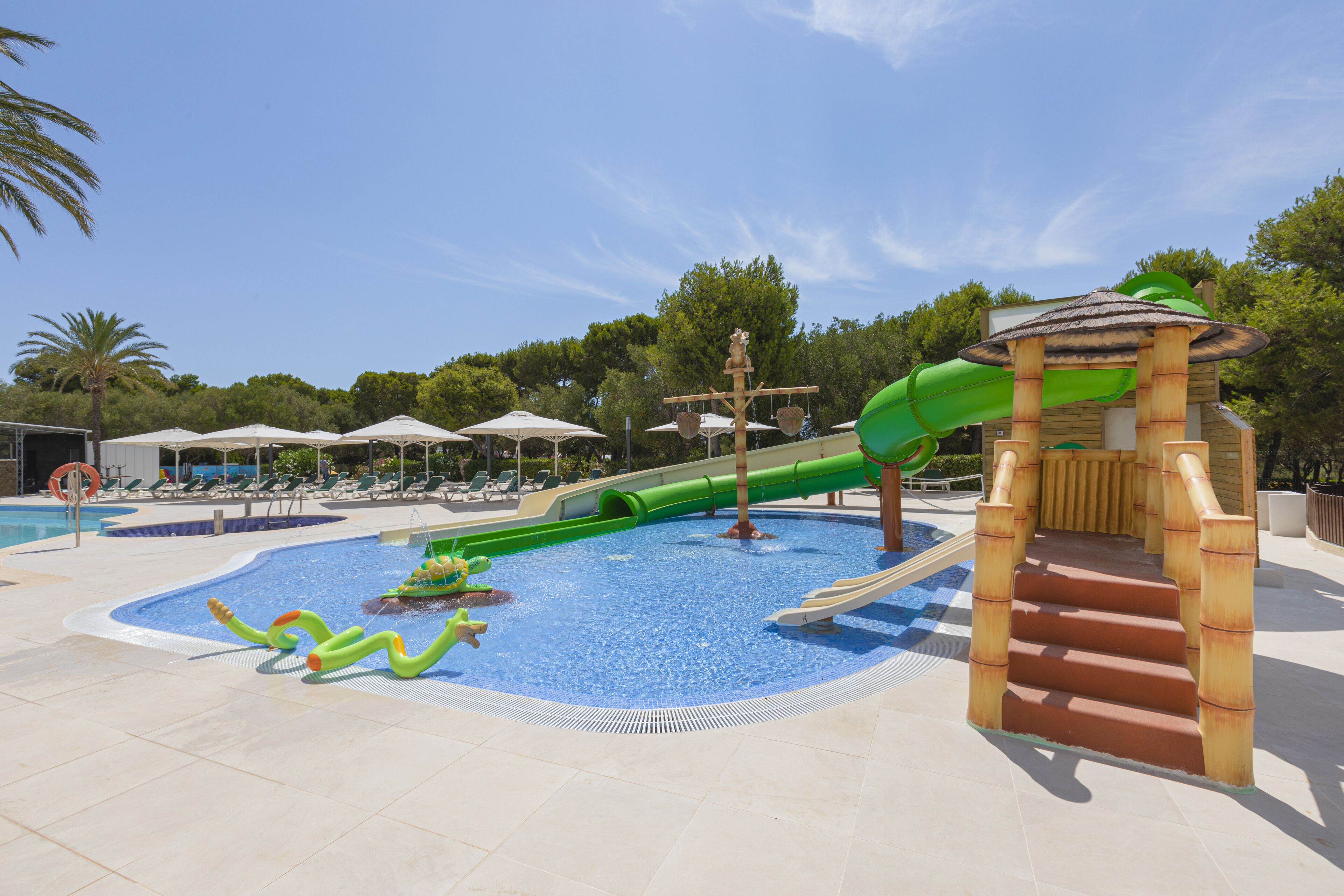 Um parque aquático com piscina, toboáguas e área de recreação.
