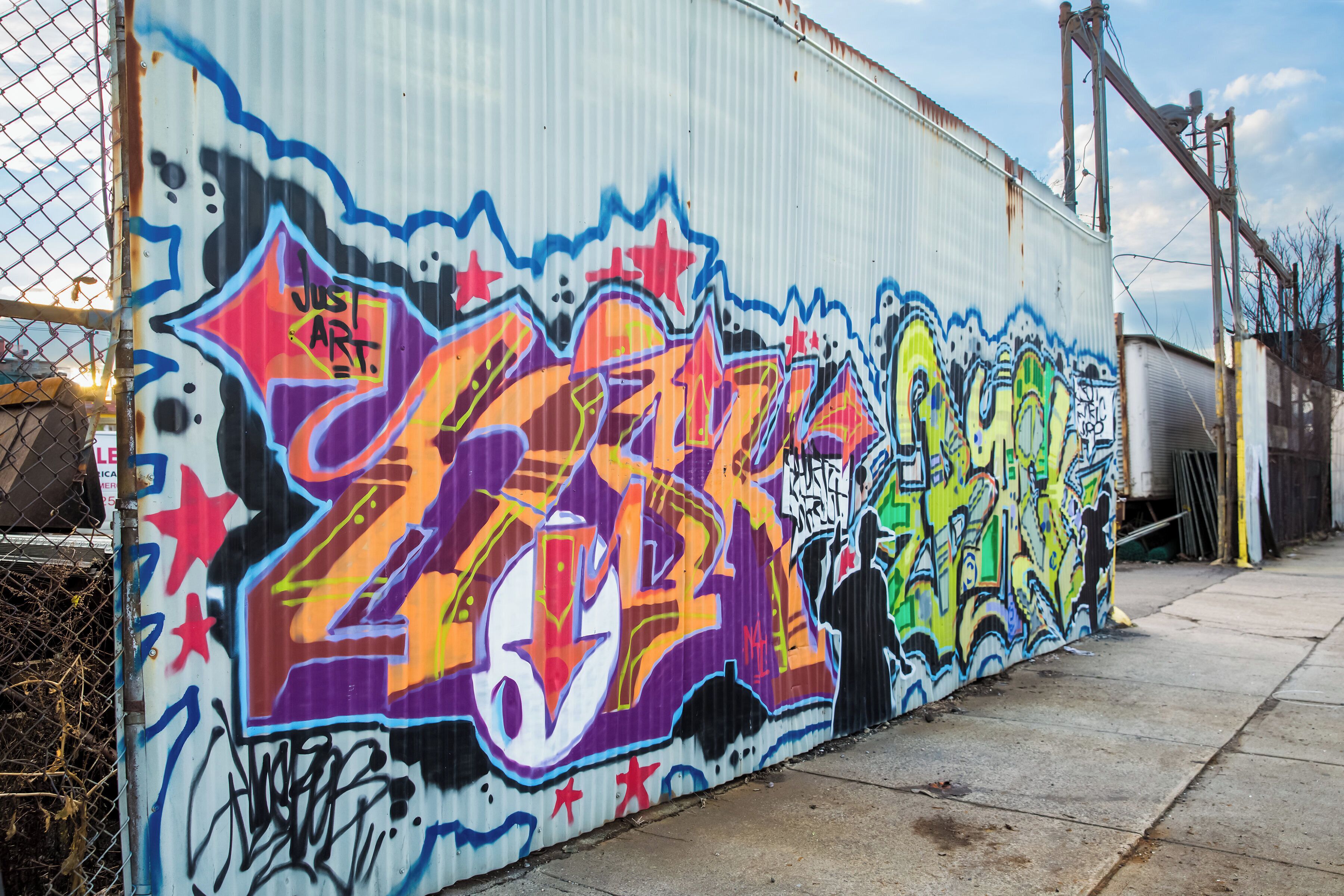 Um edifício industrial com fachada metálica e paredes cobertas de grafite.