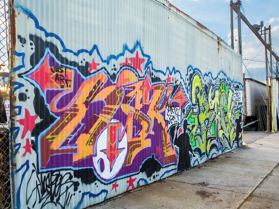 Um edifício industrial com fachada metálica e paredes cobertas de grafite.