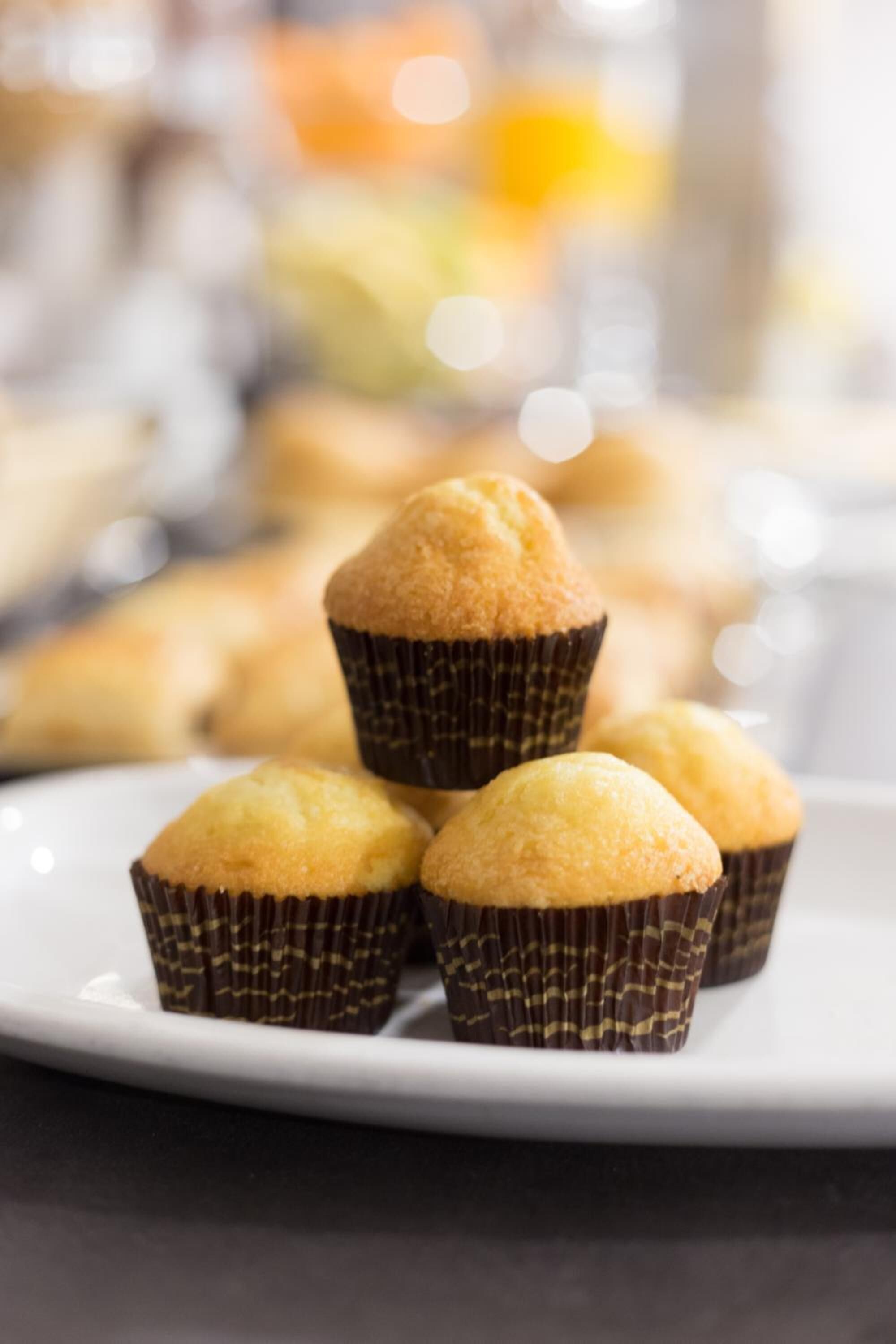 Um prato com quatro muffins em copos de papel pardo.
