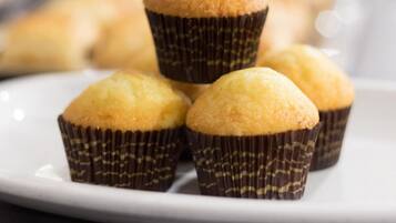 Um prato com quatro muffins em copos de papel pardo.