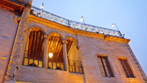 Um edifício de pedra com janelas em arco e uma placa que diz 'Cave Konak Cafe Restaurant'.