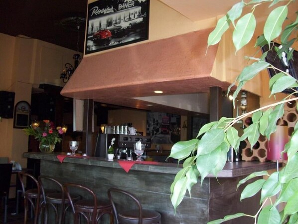 Uma área de bar com balcão, cadeiras e uma placa suspensa.