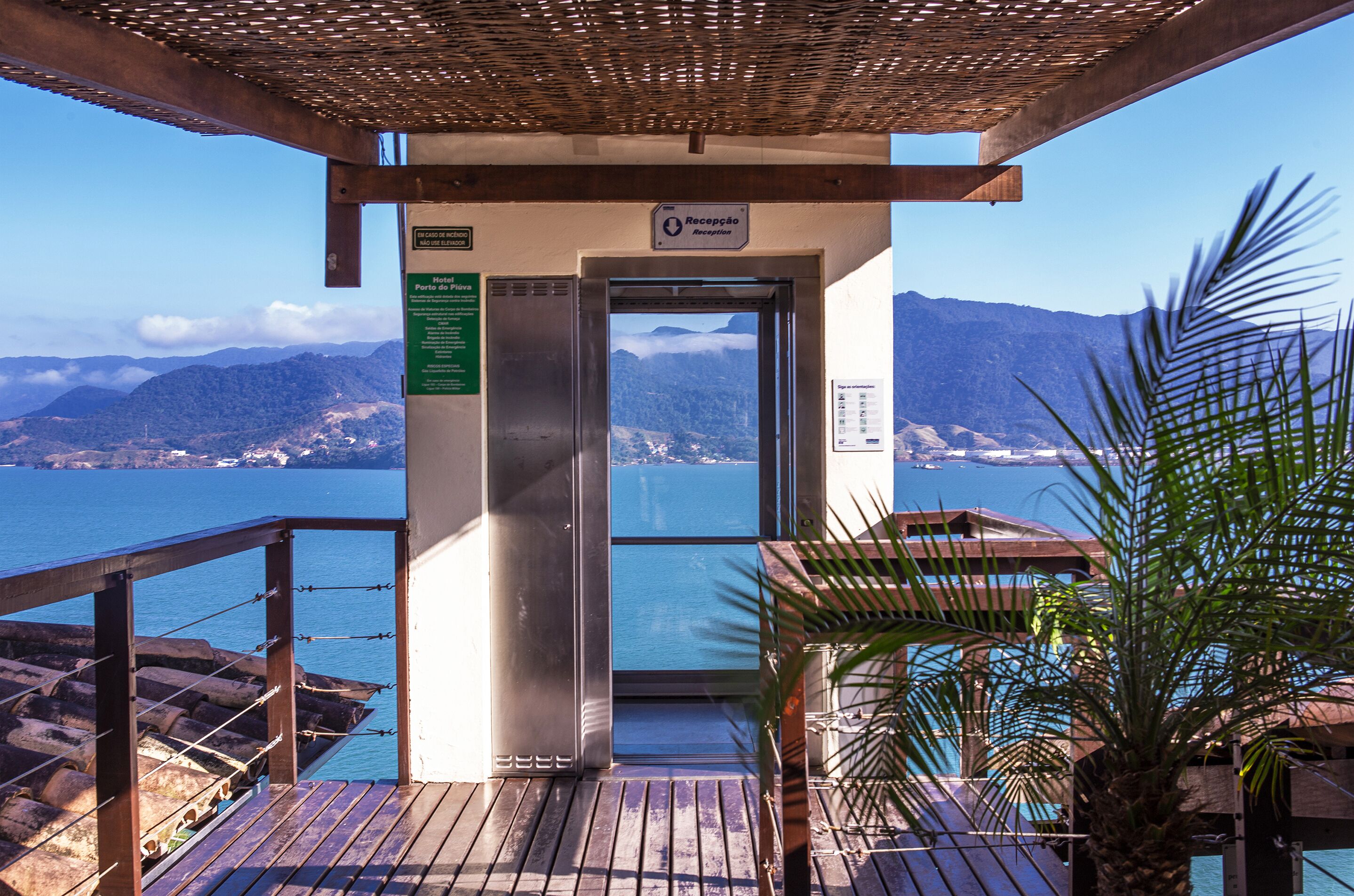 Uma área de recepção com vista para o mar e montanhas.
