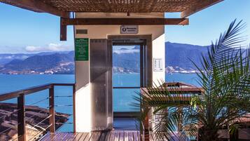 Uma área de recepção com vista para o mar e montanhas.