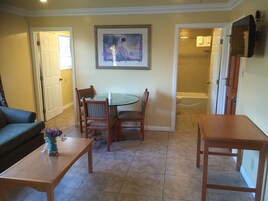 Suite Executiva, várias camas, kitchenette | Sala de estar | Televisor 