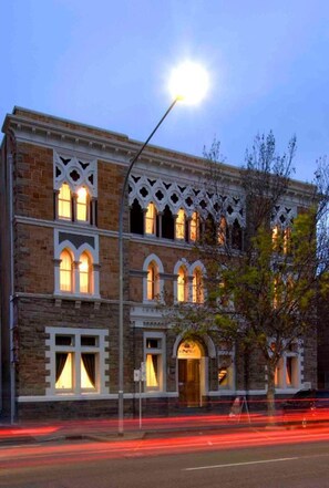 Um edifício histórico com várias janelas em arco e uma entrada central.