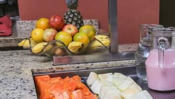 Exposição de frutas com maçãs, bananas e uma abacaxi.
