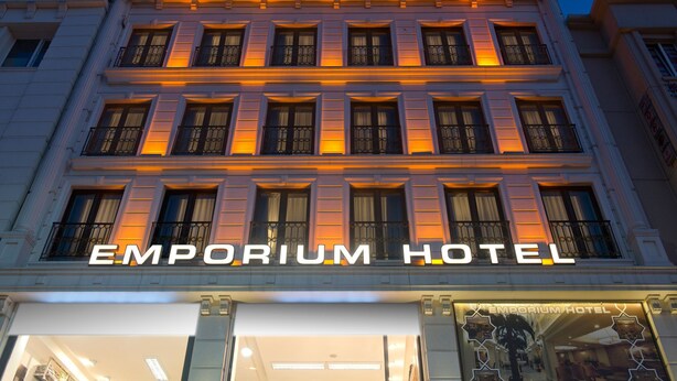 Exterior do Emporium Hotel com estilo arquitetônico clássico, apresentando diversas janelas e uma entrada imponente.