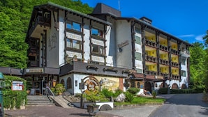 Um edifício tradicional com várias varandas, um letreiro de restaurante e um mural.