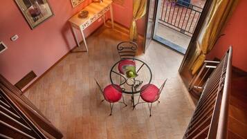 Uma escadaria leva a uma varanda com mesa, cadeiras e um banco, oferecendo vista para o exterior.
