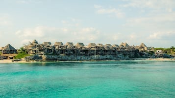 Na praia, areia branca, espreguiçadeiras, guarda-sóis