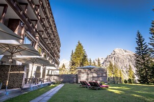Um hotel com área externa para sentar e vista para as montanhas.