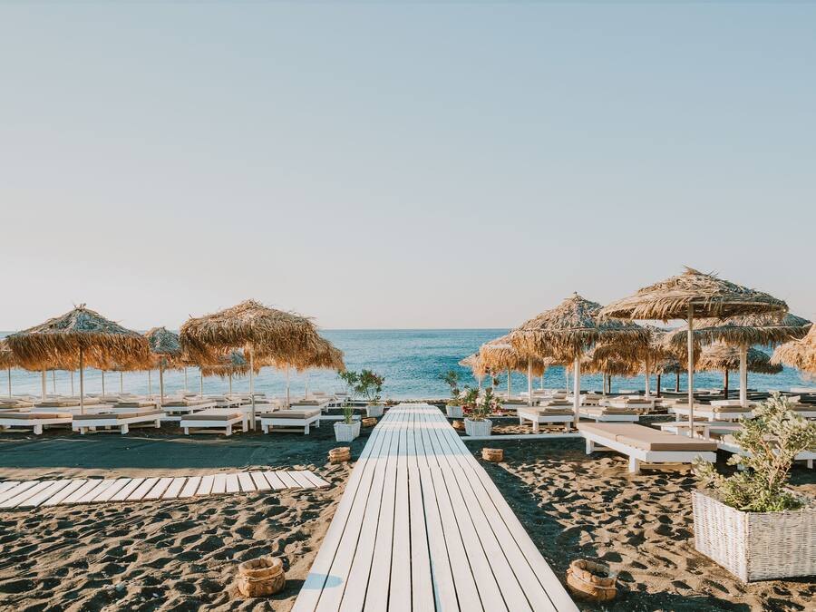 Uma praia privada, praia de areia negra, espreguiçadeiras