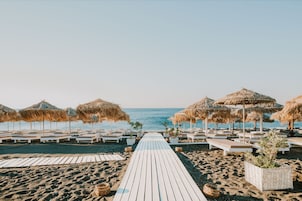 Uma praia privada, praia de areia negra, espreguiçadeiras 