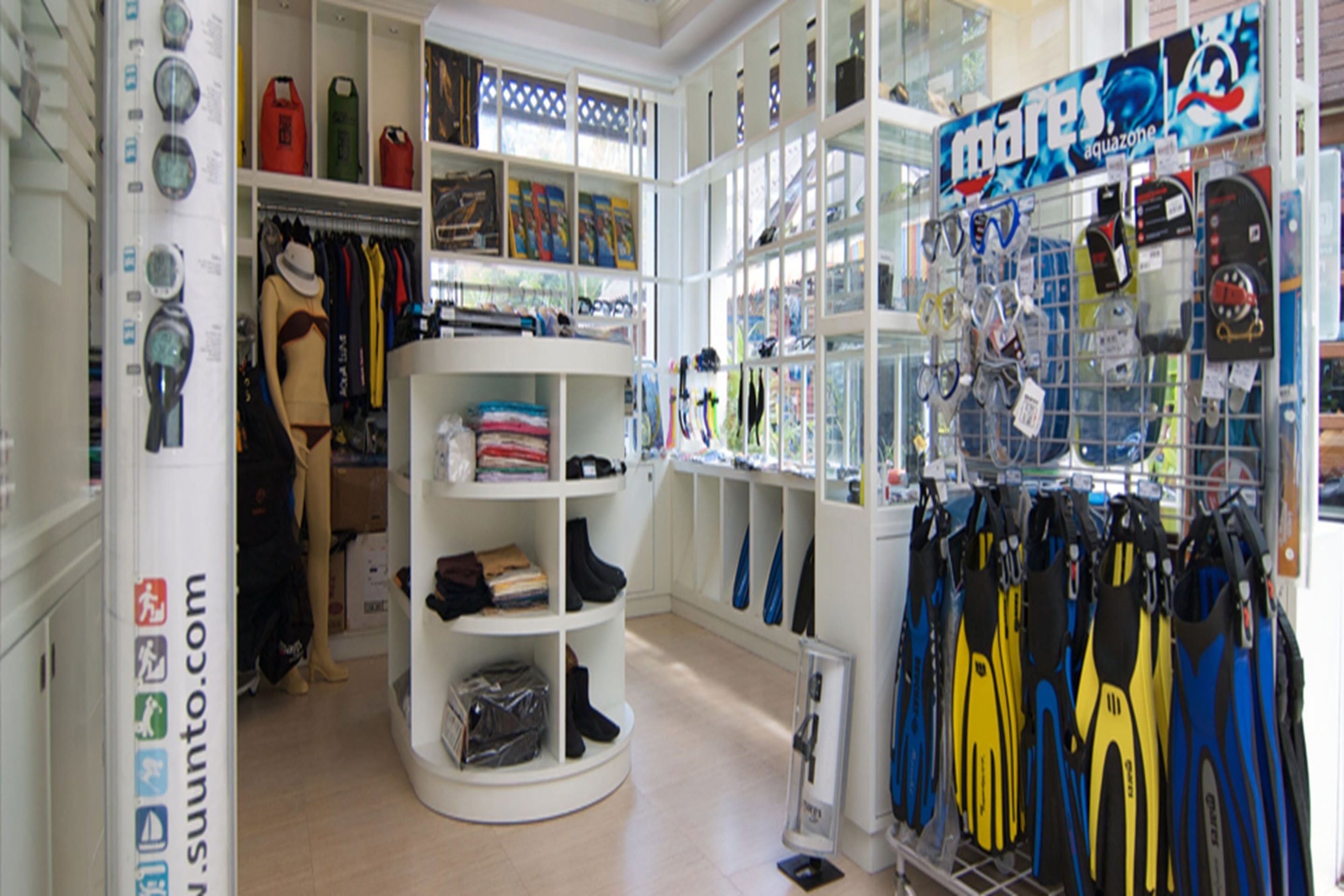 Loja com prateleiras cheias de trajes de banho, acessórios e equipamentos de mergulho.
