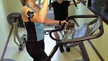 Uma academia com esteiras e equipamentos de exercícios.