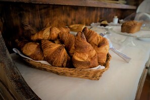 Uma cesta com croissants sobre uma mesa.