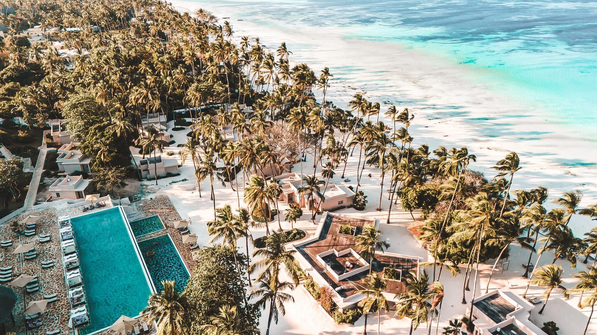 Na praia, espreguiçadeiras, guarda-sóis, toalhas de praia 