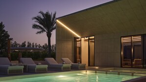 Uma área de piscina moderna ao ar livre, com cadeiras de descanso e vista desimpedida da piscina.
