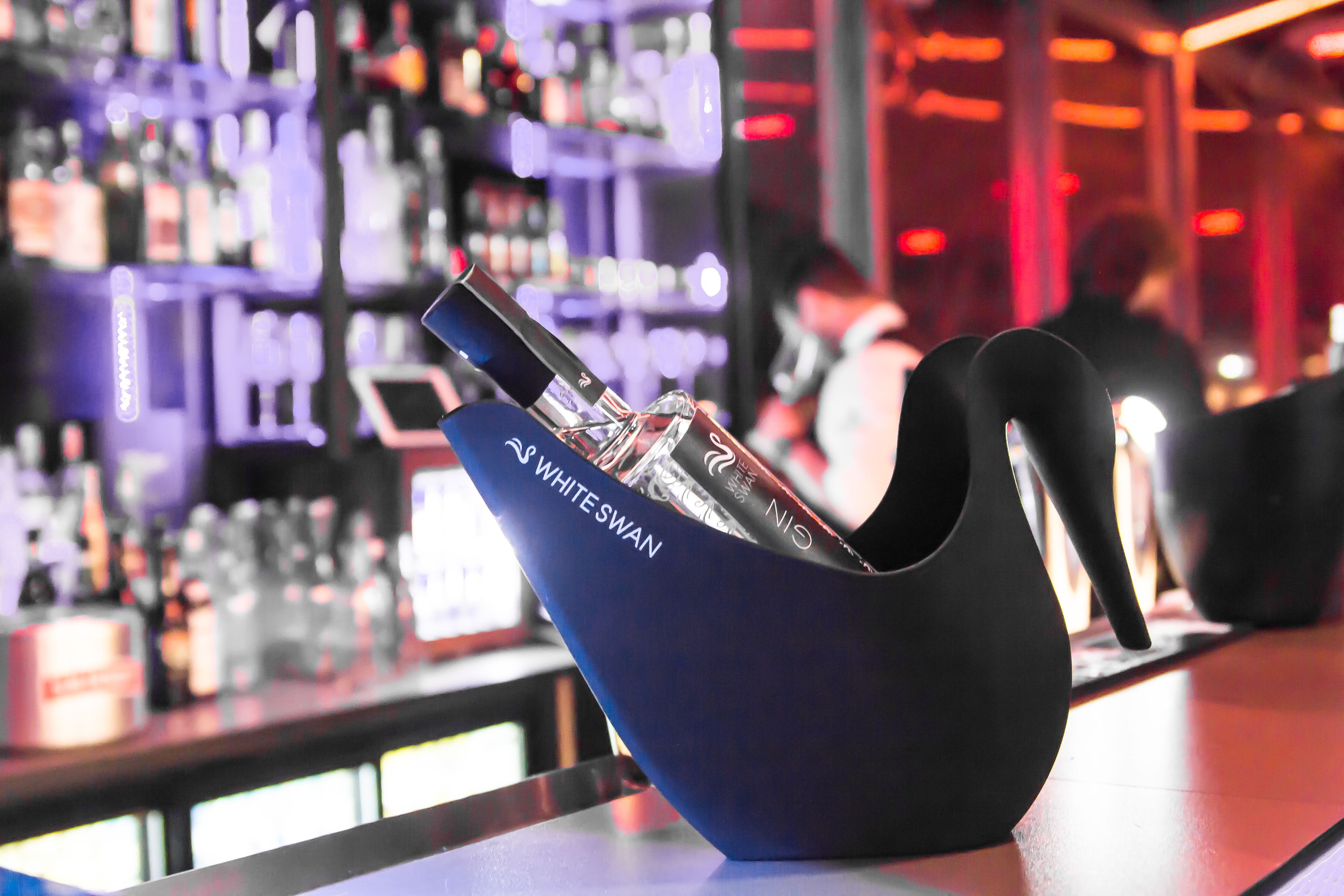 Uma área de bar com bancada azul e um banquinho preto.