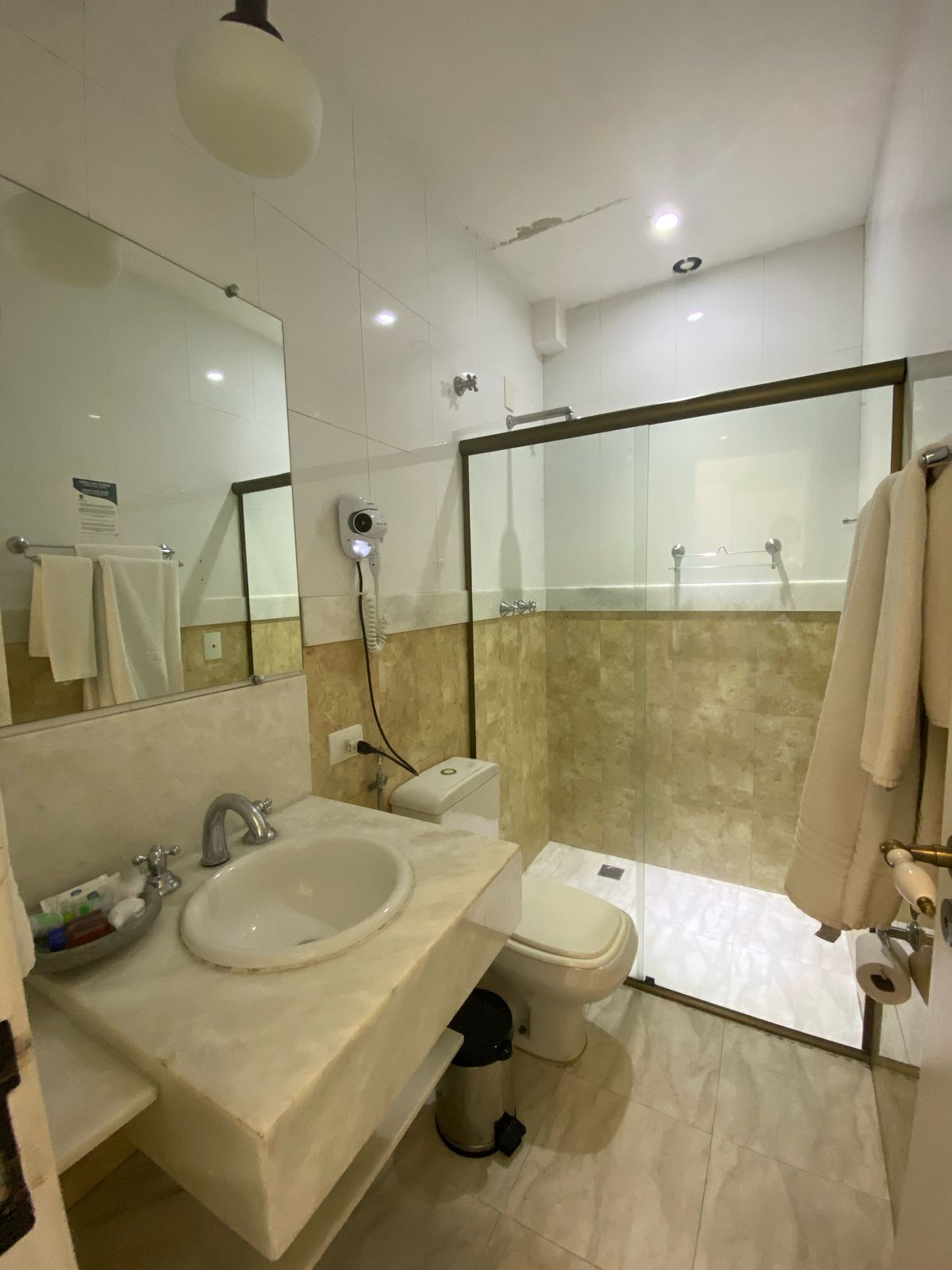 Uma casa de banho moderna com lavatório, sanita e cabine de duche com vidro.