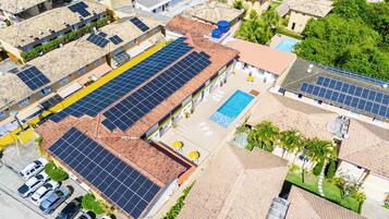 Área residencial com várias casas, cada uma equipada com painéis solares nos telhados.