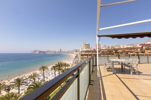 Varanda com vista para a praia e paisagem urbana.