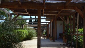 Uma galeria coberta com vigas de madeira e plantas em vasos.