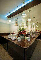 Disposição de buffet com balcão de mármore, pratos empilhados e um arranjo floral.