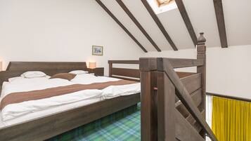 Quarto com cama de madeira, claraboia e vista para o exterior.