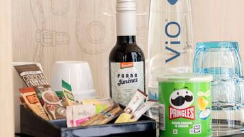 Um minibisco com uma garrafa de vinho Parra Jimenez, salgadinhos Pringles e diversos pacotes de café.