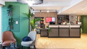 Uma área de bar moderna com balcão de madeira, assentos e um quadro de cardápio.
